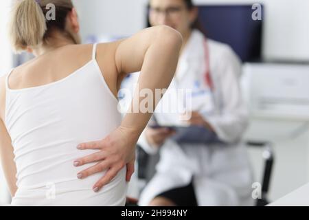 Female patient complain on back pain and touch side of body Stock Photo ...