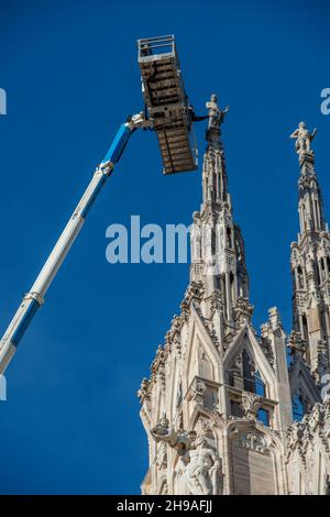 Milan Italy 1 December 2021: Technicians on lifting platform for scheduled maintenance plan and ...