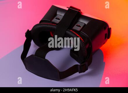 Virtual reality glasses, headphones on a pink background with orange ...