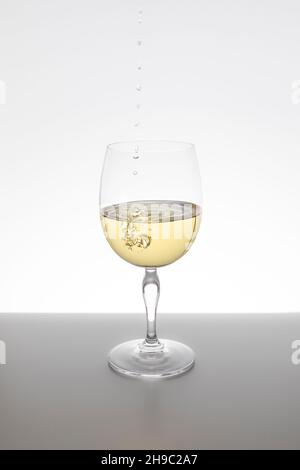 white wine falling in glass on white background Stock Photo - Alamy