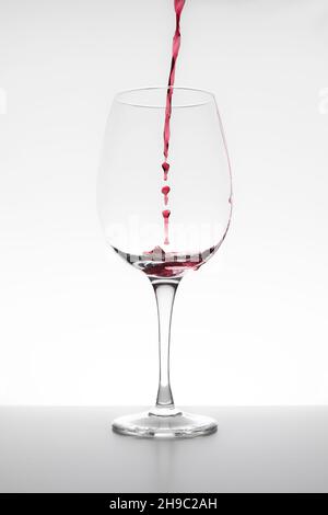 Red wine falling in glass on white background Stock Photo - Alamy