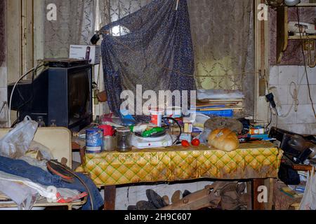 Very messy and untidy cluttered lounge room with books, boxes and ...