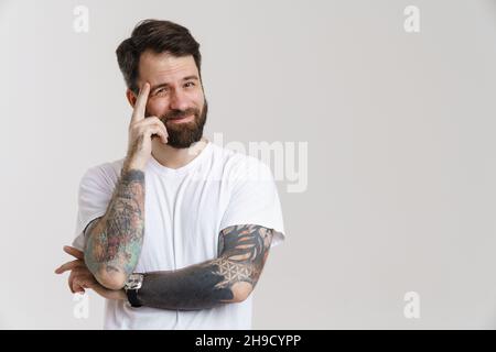 Bearded puzzled man touching his forehead and looking at camera ...