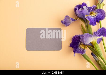 Gray business card with blue iris flowers on white concrete background ...