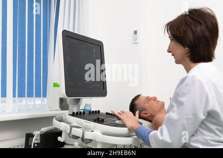 Doctor makes echocardiography of male patient using ultrasound probe ...