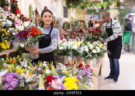 Florist in an apron creates bouquets in flower shop Stock Photo - Alamy