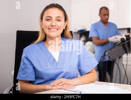 Positive female doctor cosmetologist filling medical forms Stock Photo ...
