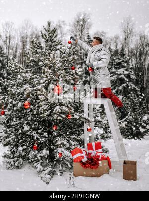 Guy decorates Christmas tree. Santa Claus with confused face Stock ...