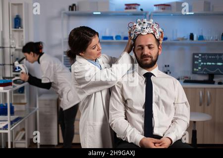 Scientist woman putting eeg headset on woman patient head during ...