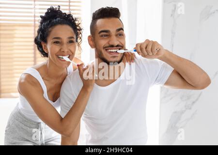 Morning Routine. Smiling Young Middle Eastern Couple Brushing Teeth In ...