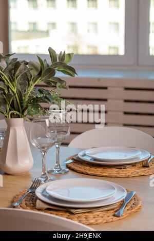 Trendy table setting with floral decor on light blue background with ...