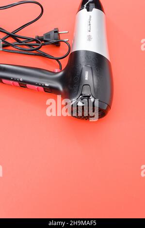 INVERIGO, ITALY - Dec 07, 2021: isolated hair dryer on a red background ...