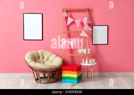 Interior of stylish room with Mexican pinata, table and shelving unit ...
