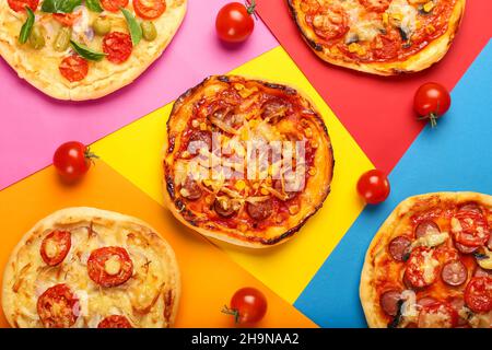 Different mini pizzas on color background Stock Photo - Alamy