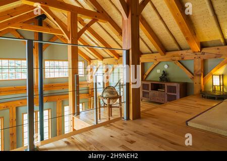 Dresser and globe on wooden stand on mezzanine of open concept design ...