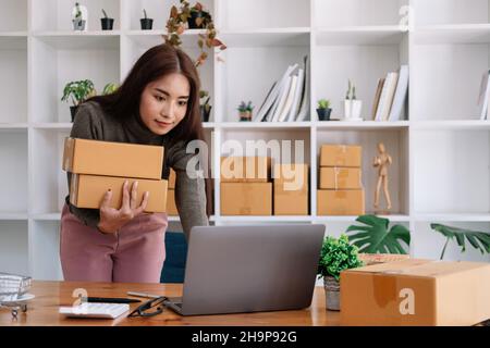 Happy young asian woman startup small business freelance with parcel ...