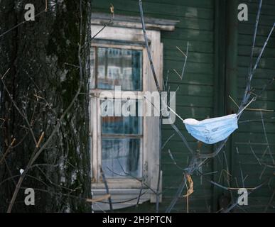 Abandoned used medicine mask tied to the tree branches Stock Photo - Alamy