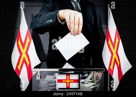 Guernsey flags, hand dropping ballot card into a box - voting, election ...