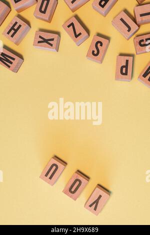 Word HOW taken from a pile of wooden letter blocks in the yellow ...