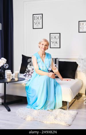 Middle age senior woman moving to a new house packing cardboard boxes ...