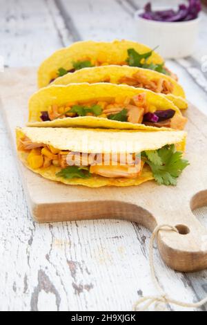 Vegan tacos with corn, purple cabbage and tomatoes on a white plate ...