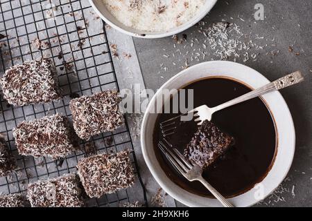 Making Lamingtons - dipping in chocolate icing Stock Photo - Alamy