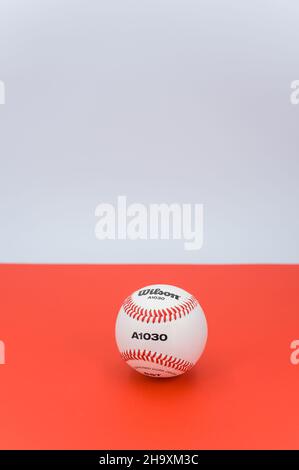 INVERIGO, ITALY - Dec 08, 2021: isolated baseball ball on orange paper ...