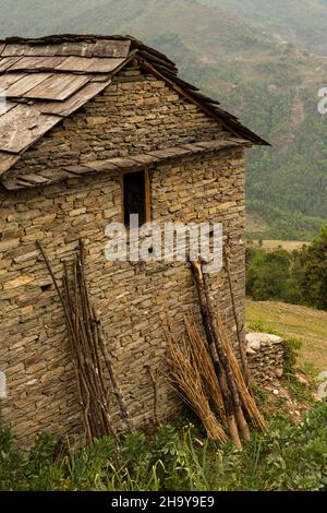 A traditional Nepalese farm building of stone with a slate tile roof in ...