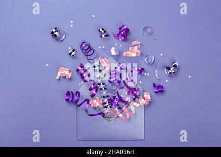 Top view of serpentine on envelope with gift bow on yellow background ...