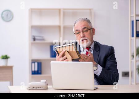 Old businessman employee missing his wife at workplace Stock Photo - Alamy