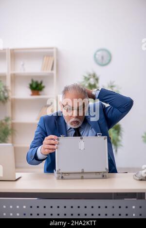 Old businessman employee in remuneration concept at home Stock Photo ...