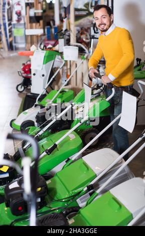 Glad guy deciding on best garden sprayer in garden equipment shop Stock ...