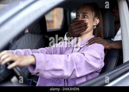 Scared woman driver look in back view mirror at small accident car ...