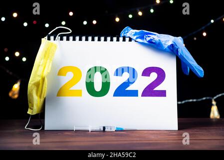 2022 medicine concept. numbers on a sheet of paper with a medical mask, gloves, against the ...