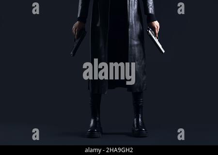 Woman with guns dressed in matrix style on dark background Stock Photo ...