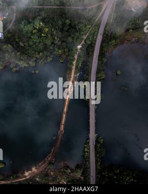 Aerial view of twin bridges over a reservoir surrounded by hills at ...