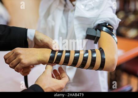 Hand wrap tefilin around the other hand. Jewish teenager 13 years old ...