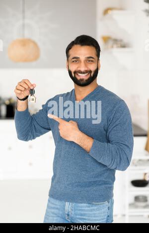 Overjoyed young indian man showing rock n roll gesture by hands, cool ...