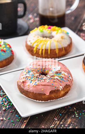 Delicious donuts decorated with different decorations on wooden table ...