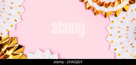 Banner with frame made of gold colored paper fans on a pink background ...