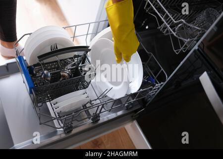 A woman takes out clean dishes from the dishwasher Stock Photo - Alamy