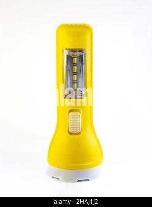 A bright yellow light bulb laying on a wet pavement in a bustling city ...