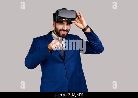 Young hispanic man playing with virtual reality glasses sitting on the ...