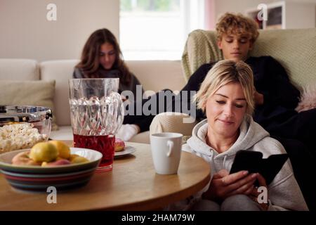 Family using smart phones in living room Stock Photo - Alamy