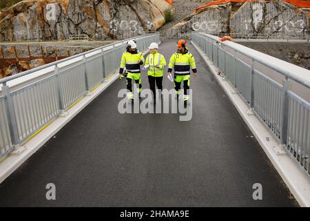 Engineers in reflective clothing walking on bridge Stock Photo - Alamy