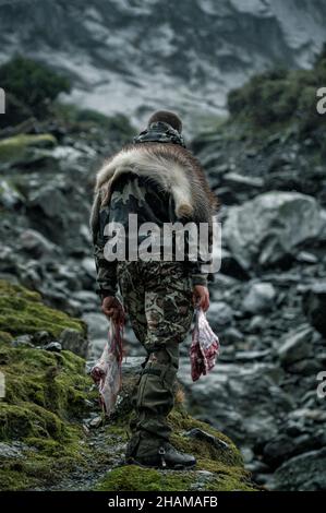 Hunter in mountains carrying meat Stock Photo - Alamy