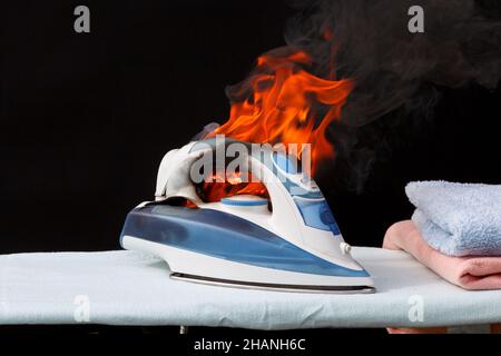 Iron in flames of fire, faulty wiring, cause of fire Stock Photo - Alamy