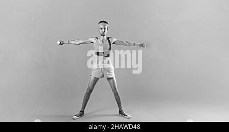 Funny retro sport nerd lifting weights on yellow background Stock Photo ...