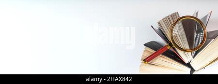 Top view of magnifier glass and empty notebook on light grey stone ...