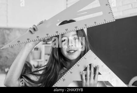 Back to school. School girl hold ruler measuring isolated on yellow ...